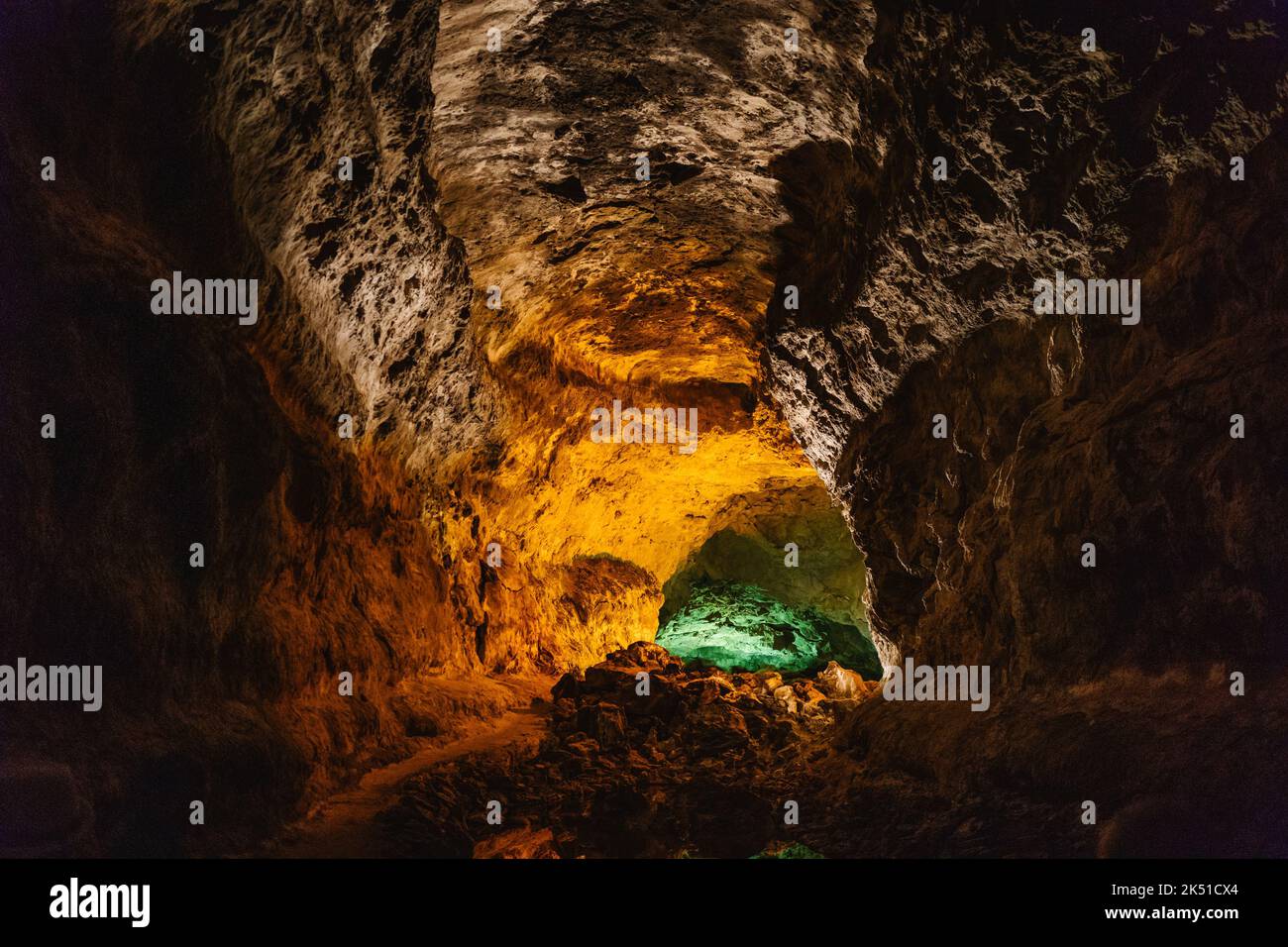 Crystal stalactites of emerald color hanging from rough ceiling of ...