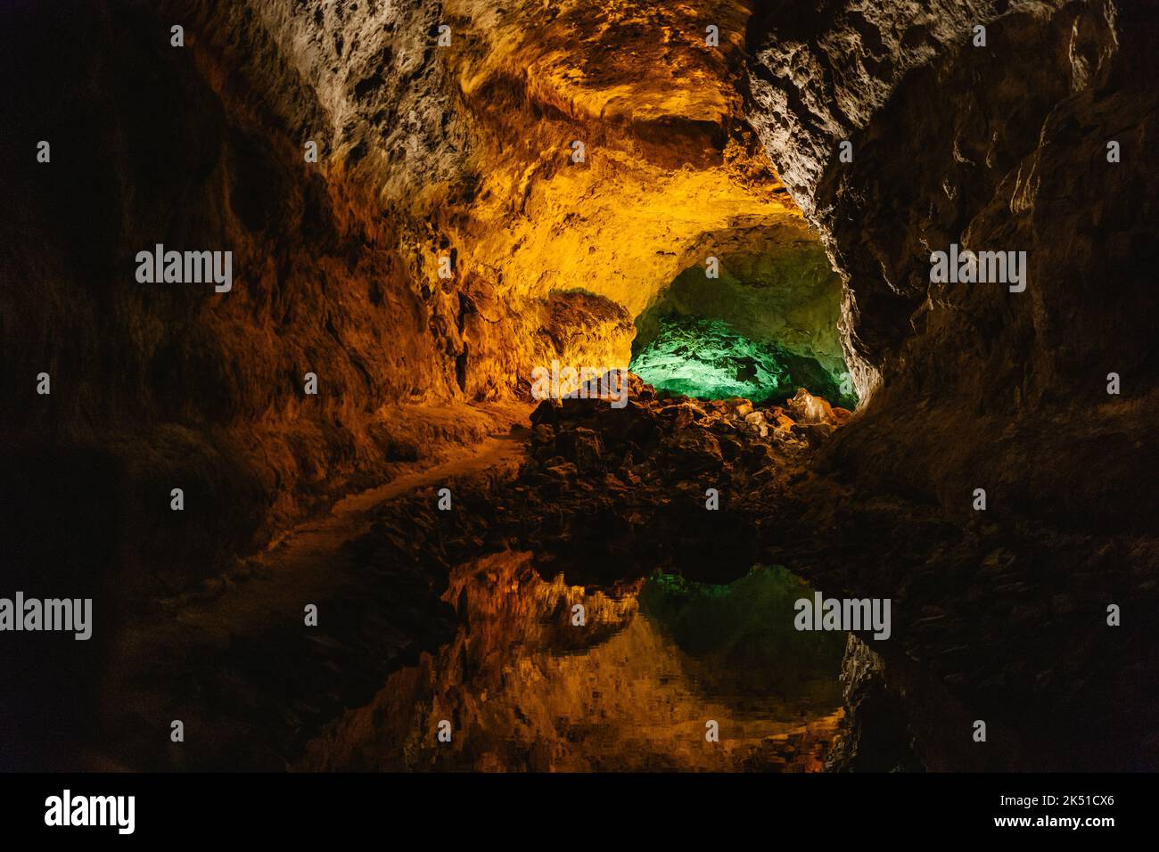 Crystal stalactites of emerald color hanging from rough ceiling of ...