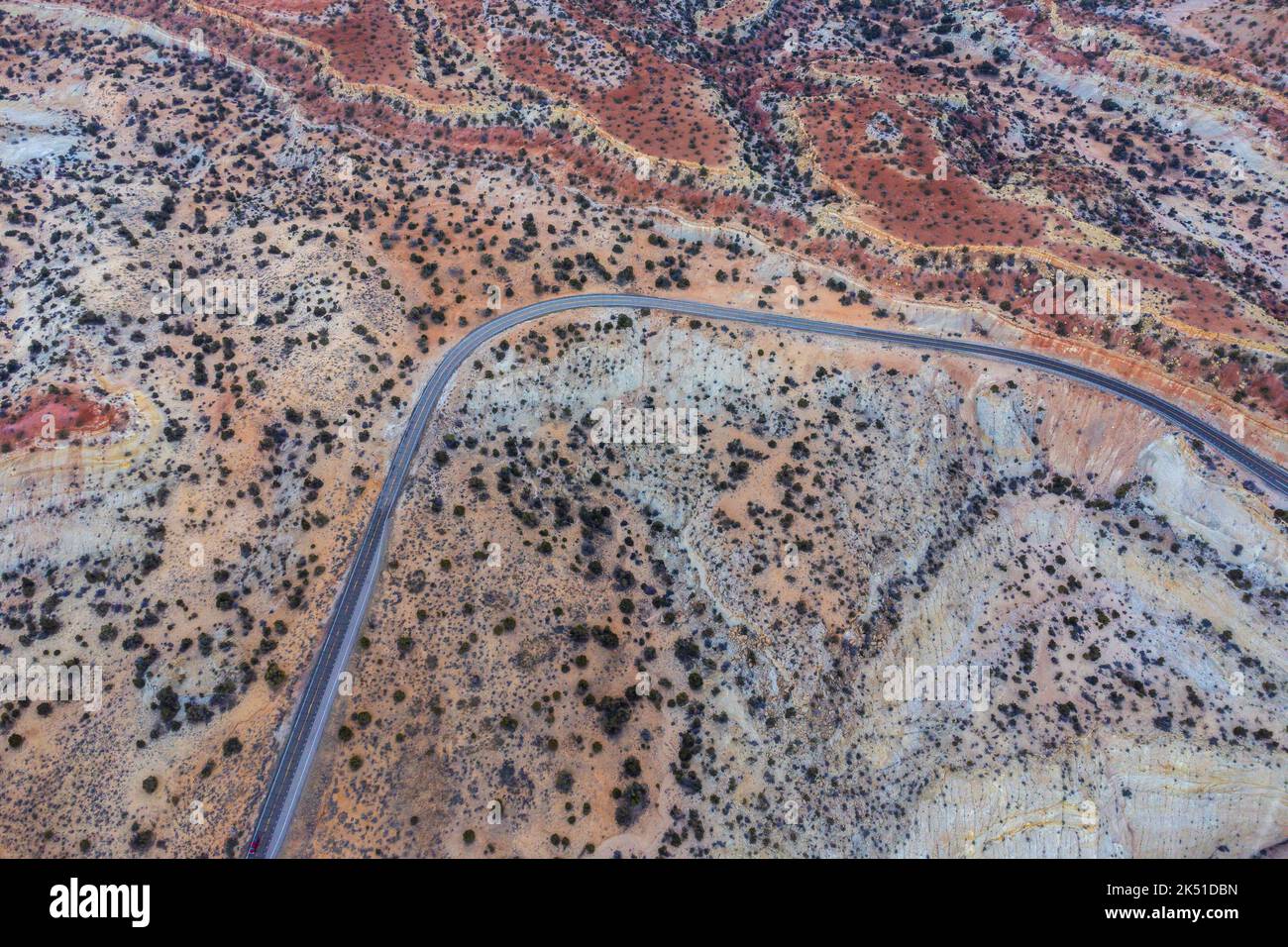 Scenic aerial view of long curve highway going through rough terrain of ...