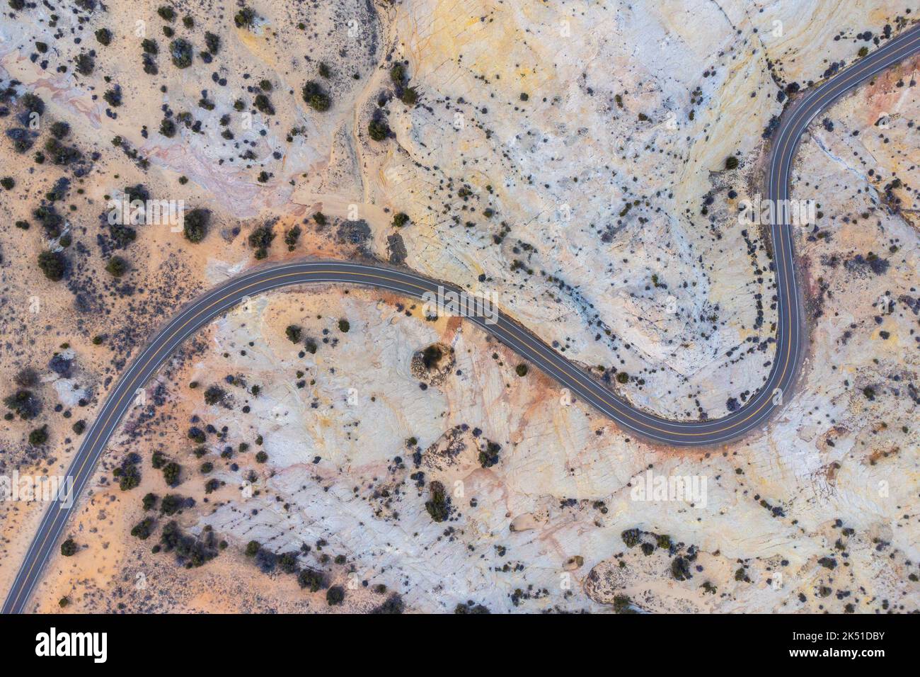 Scenic aerial view of long curve highway going through rough terrain of ...