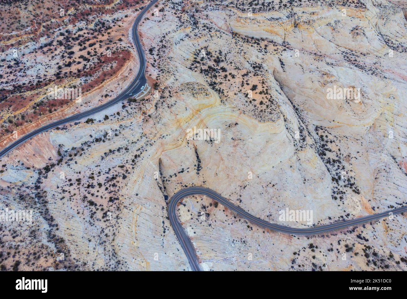 Scenic aerial view of long curve highway going through rough terrain of ...
