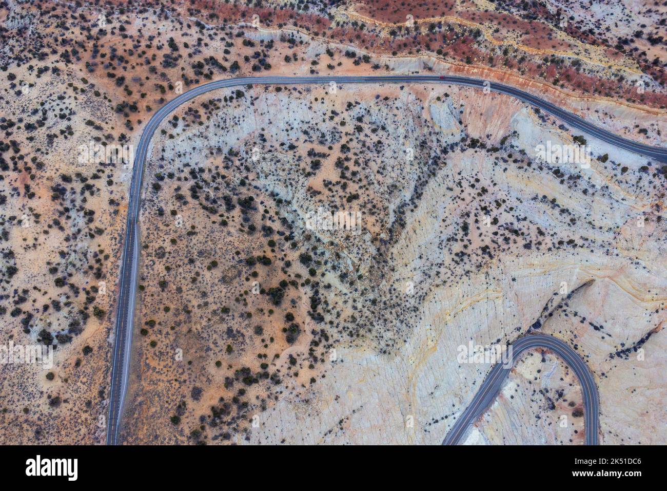 Scenic aerial view of long curve highway going through rough terrain of ...