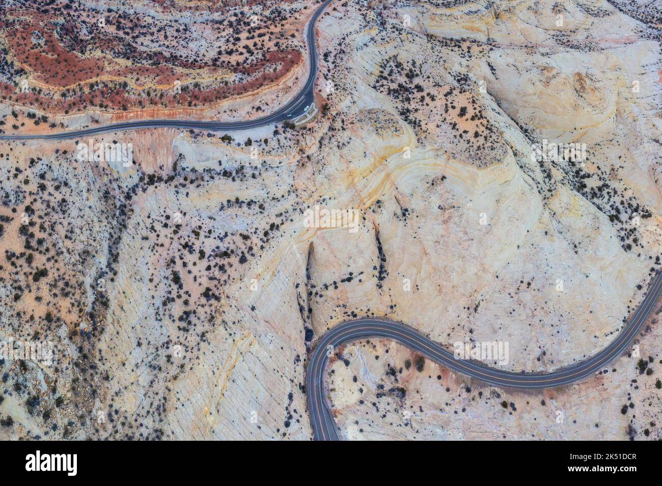 Scenic aerial view of long curve highway going through rough terrain of ...