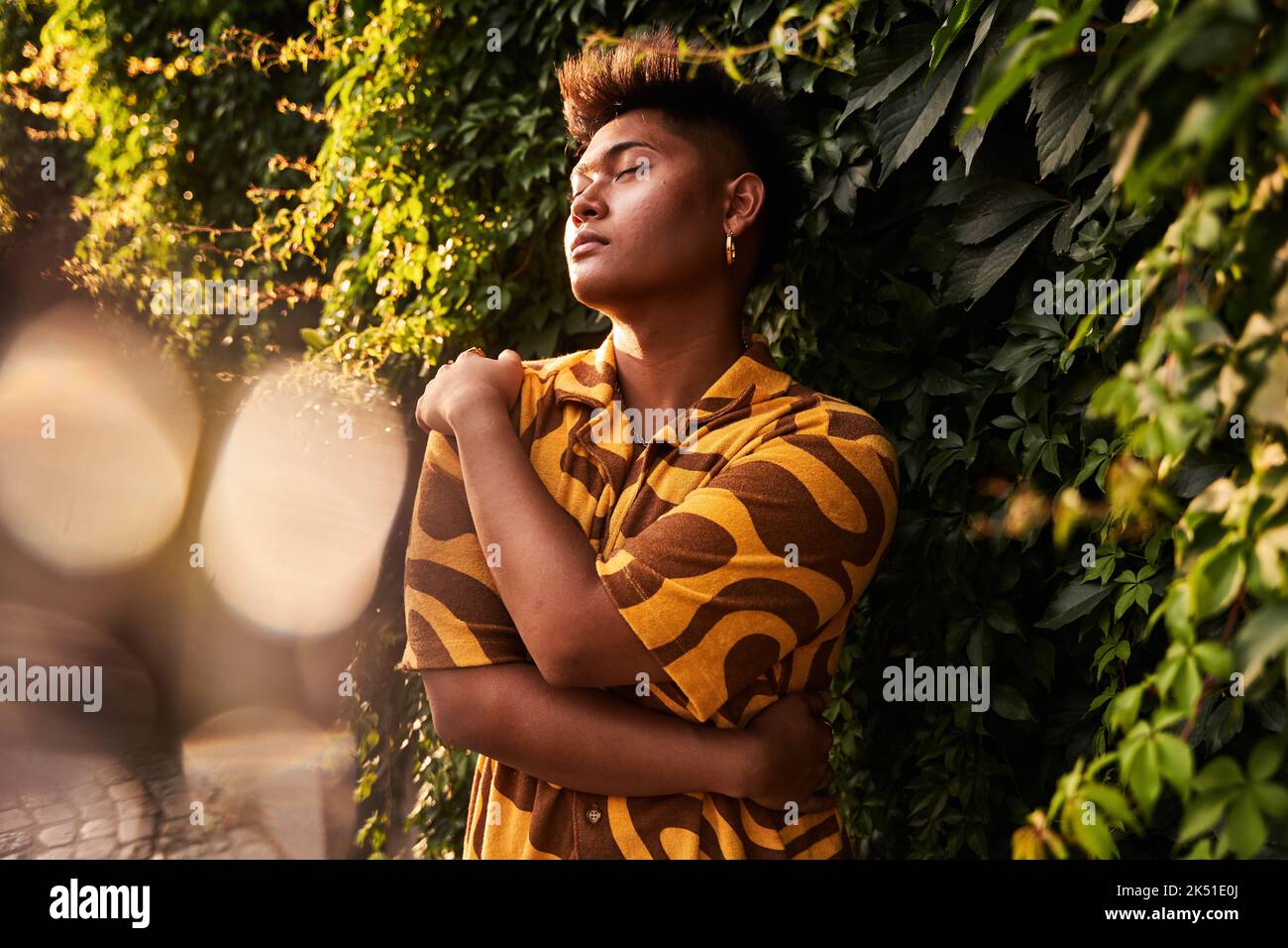 Dreamy young Filipino non binary man wearing cool shirt with earring ...