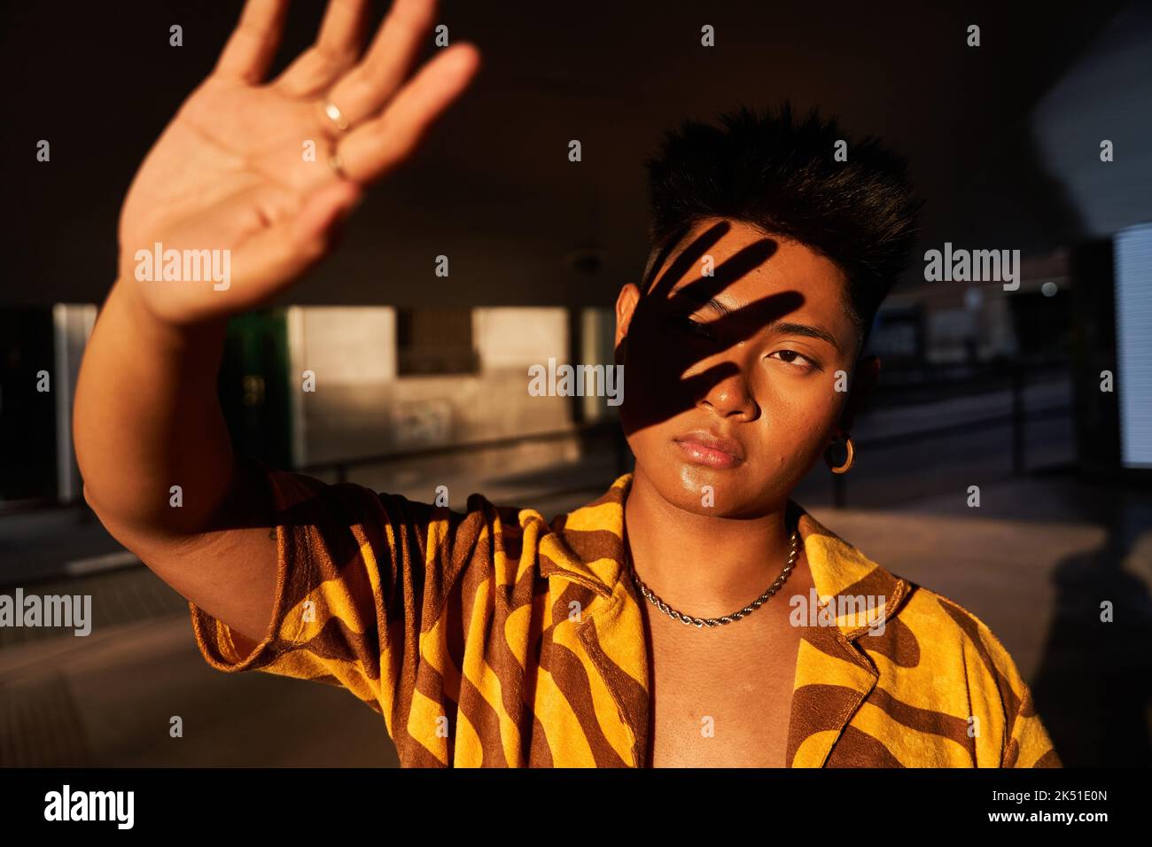Confident Asian male wearing cool shirt and accessories looking away ...