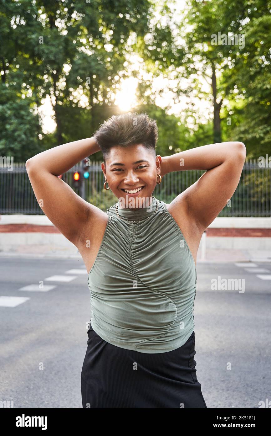 Cheerful Asian transgender woman with short hair and with pimples on ...