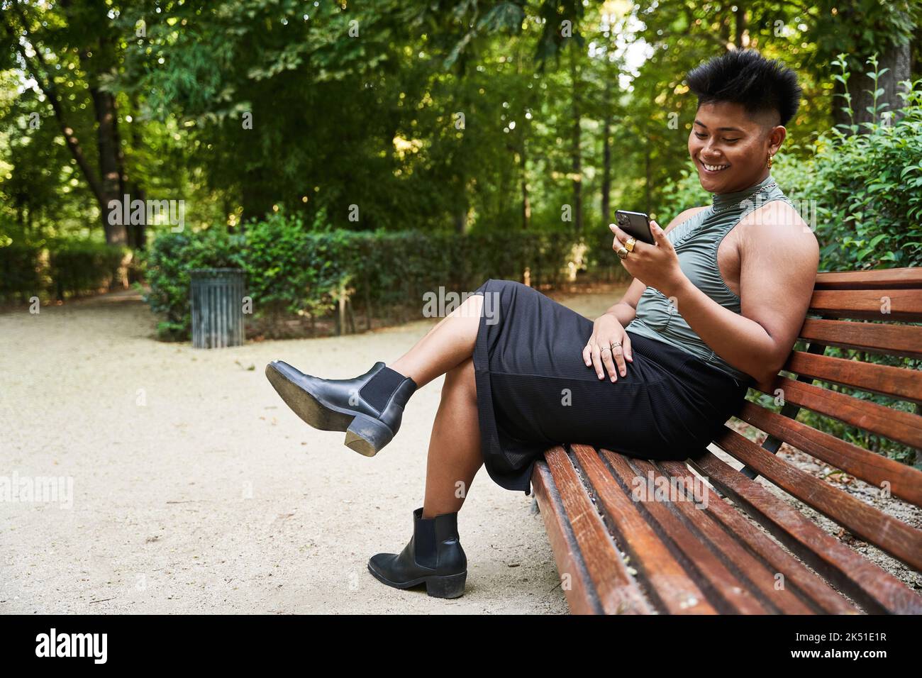 Full body happy Asian non binary person in feminine clothes smiling and ...