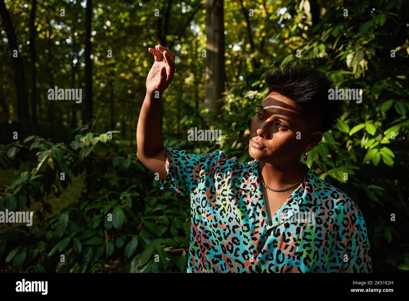 Confident Asian male wearing cool shirt and accessories looking away ...