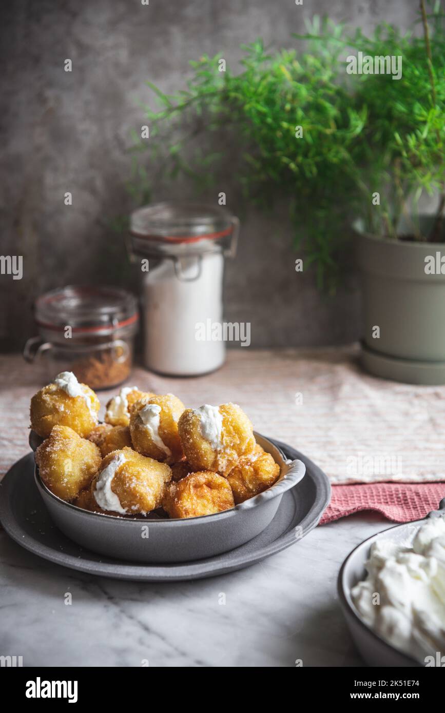 Bowl with crunchy nun's puffs bites stuffed with cream cheese placed on ...