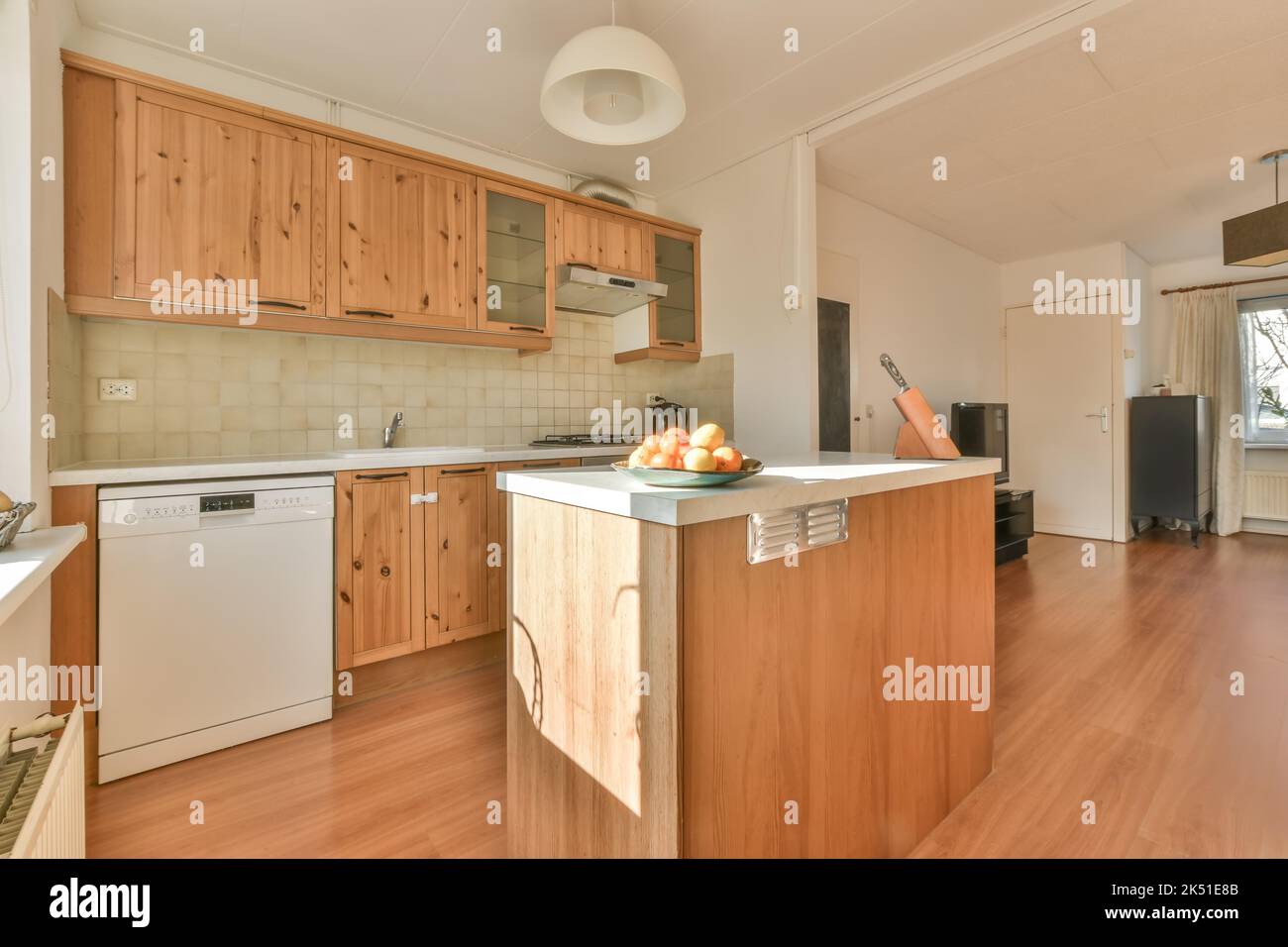 Wooden kitchen with table near living room in modern open plan flat ...