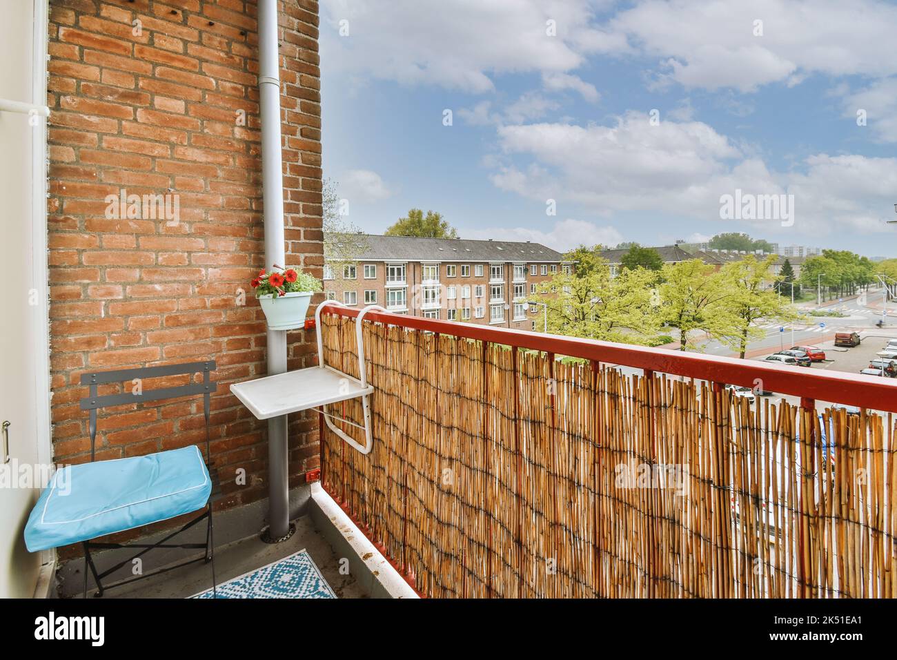 Narrow brick balcony with metal railings, wooden chair and door Stock ...