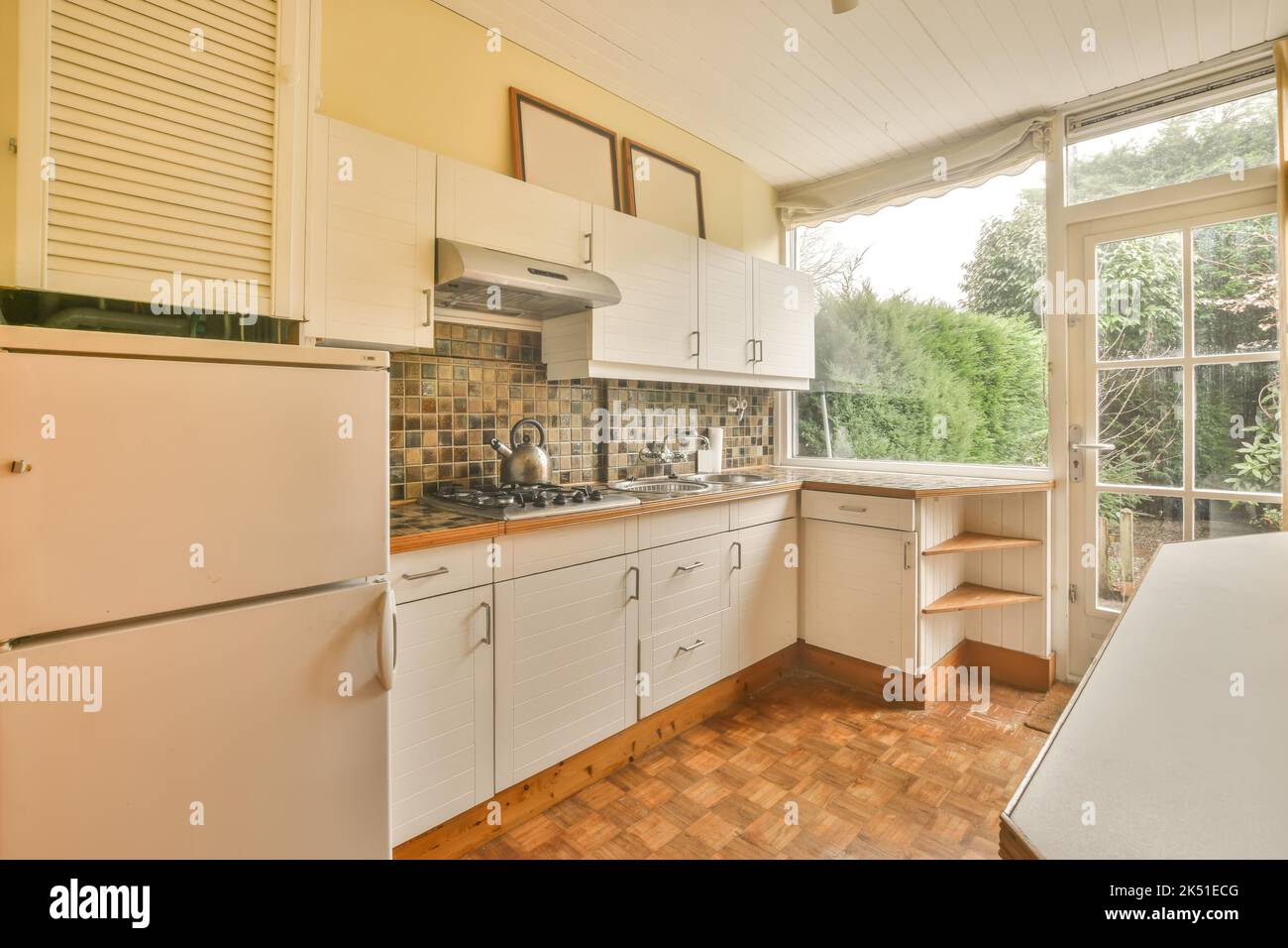 Cabinets with drawers and exhaust hood located near big window in ...