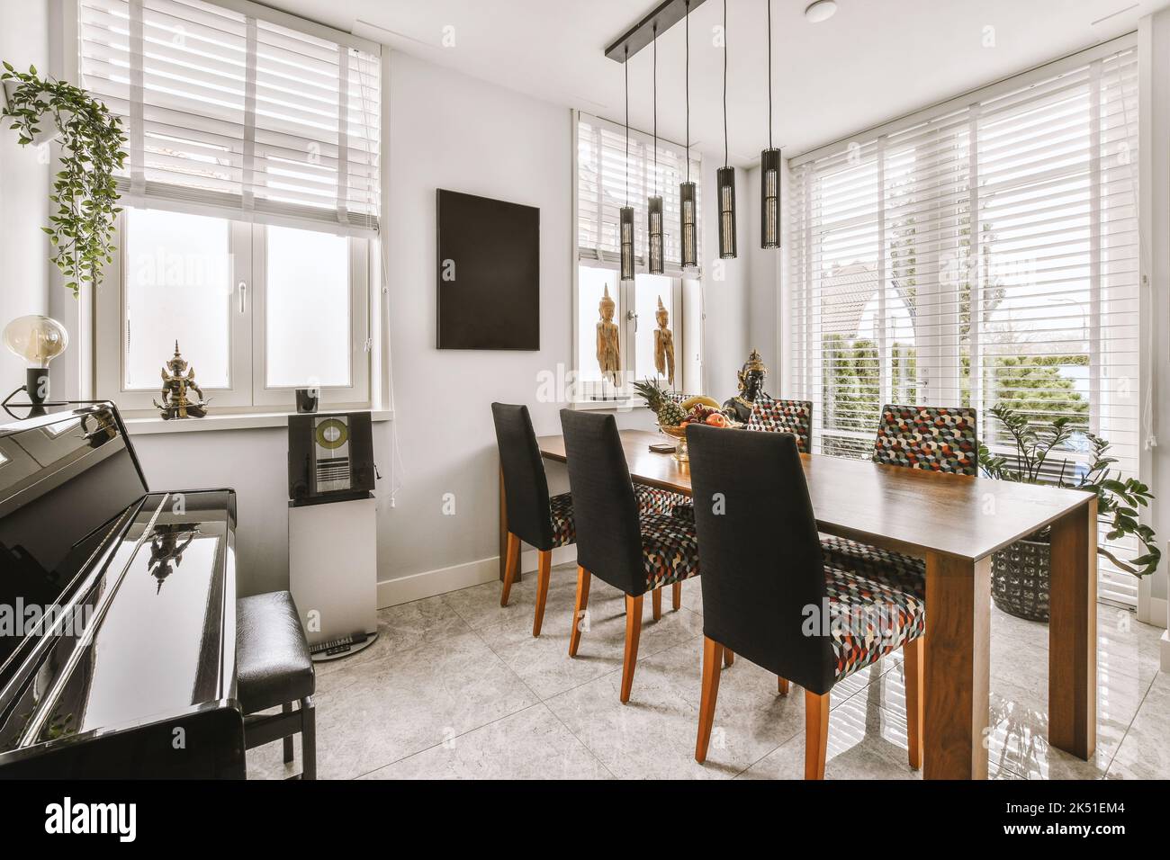 Wooden table with flowers placed in stylish light spacious dining room ...