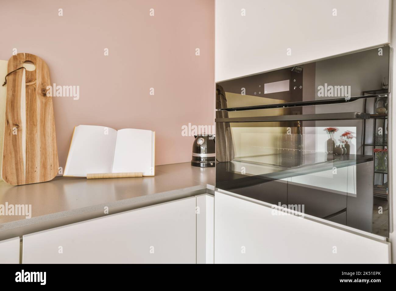 Counter with white cupboards and modern built in appliances placed in ...