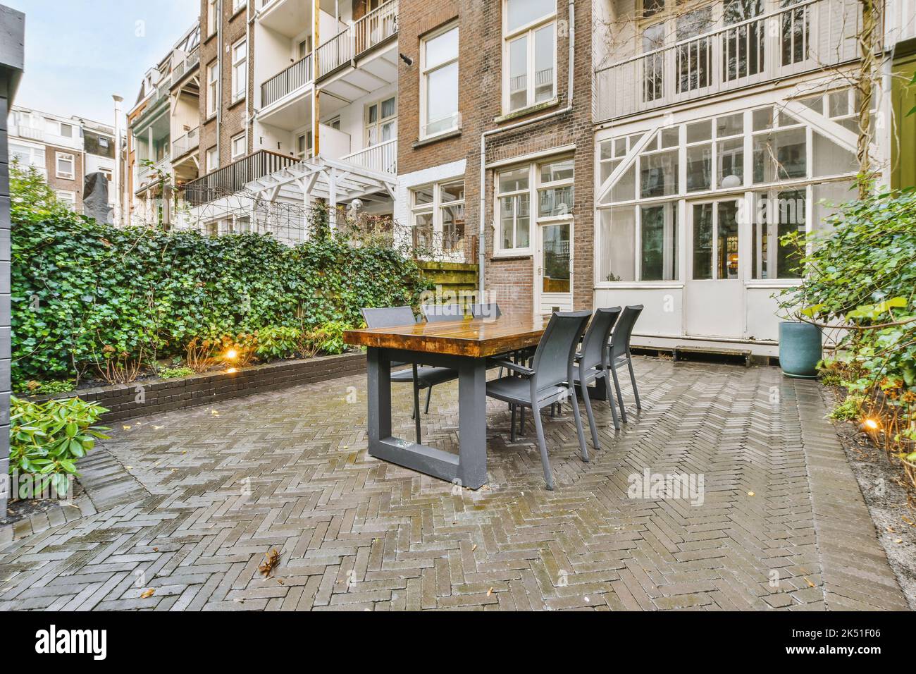 big and green terrace among buildings with table and chairs Stock Photo ...