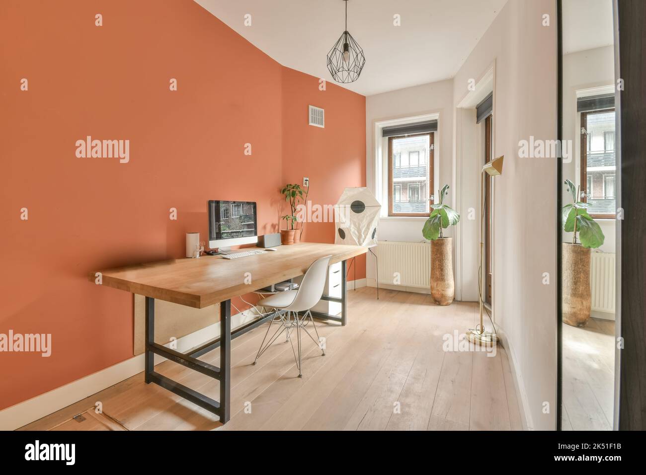 Computer table placed near window in sunny study room with decorative ...