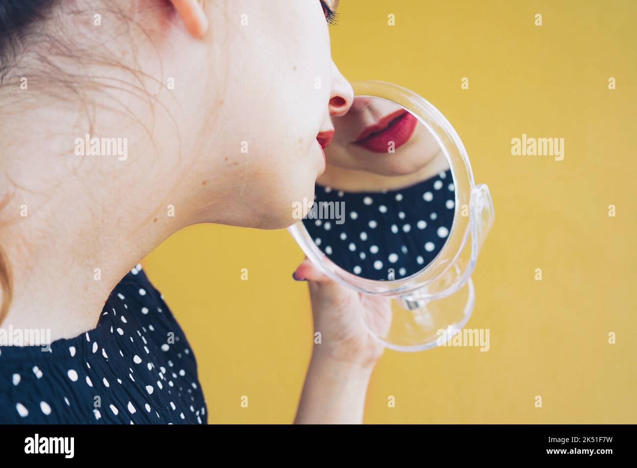 Side view of crop young female with red lips and dark hair looking at ...