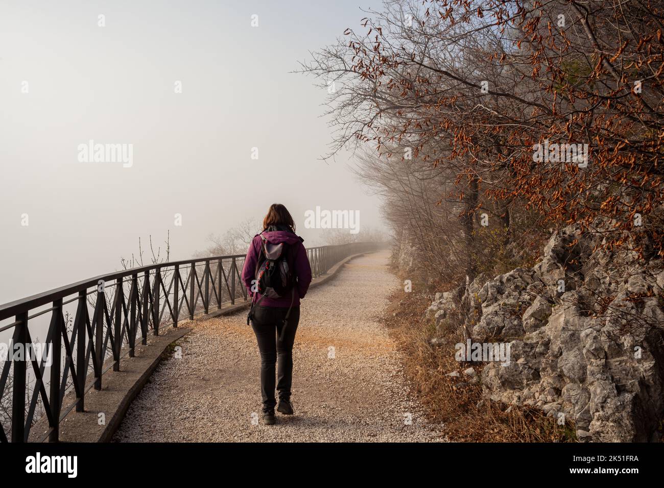 Back view of a Woman walking alone on rural misty path called Napoleonica, Trieste Stock Photo ...