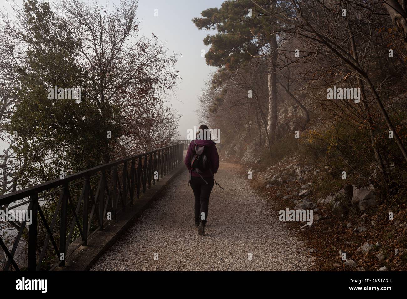 Back view of a Woman walking alone on rural misty path called Napoleonica, Trieste Stock Photo ...