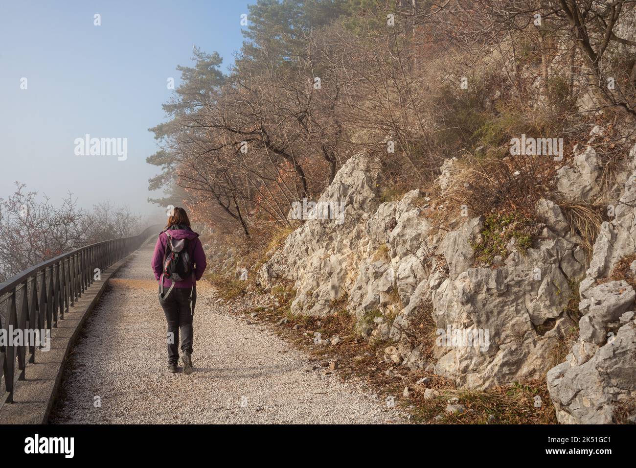 Back view of a Woman walking alone on rural misty path called Napoleonica, Trieste Stock Photo ...