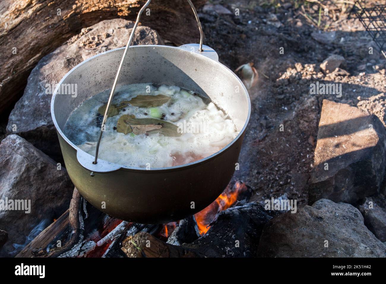 Boiling cauldron hangs over an open fire, camping meal Stock Photo - Alamy