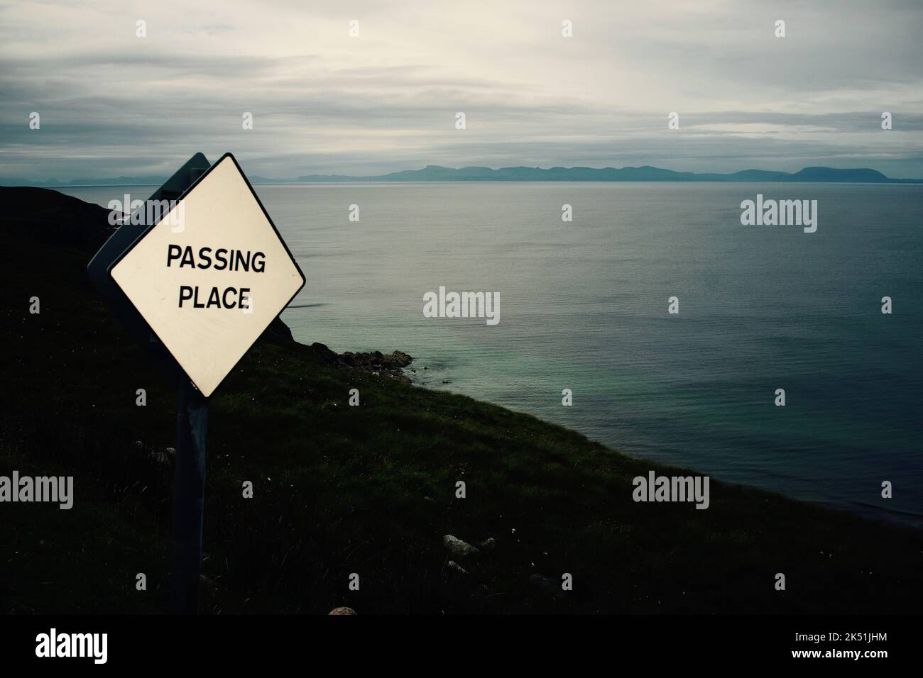 An isolated Passing Place sign with the background of a sea and ...
