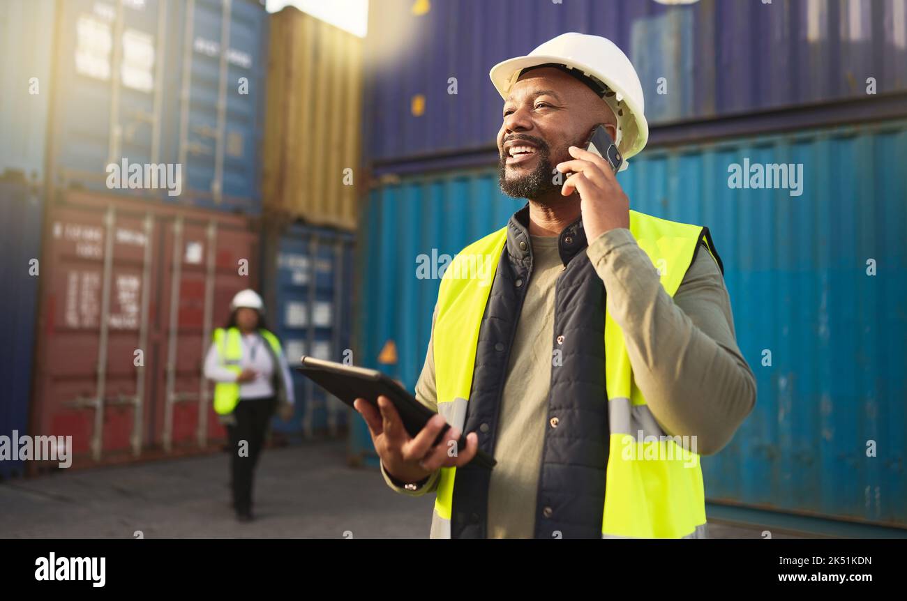 Logistics, shipping and construction worker on the phone with tablet in shipyard. Transportation ...