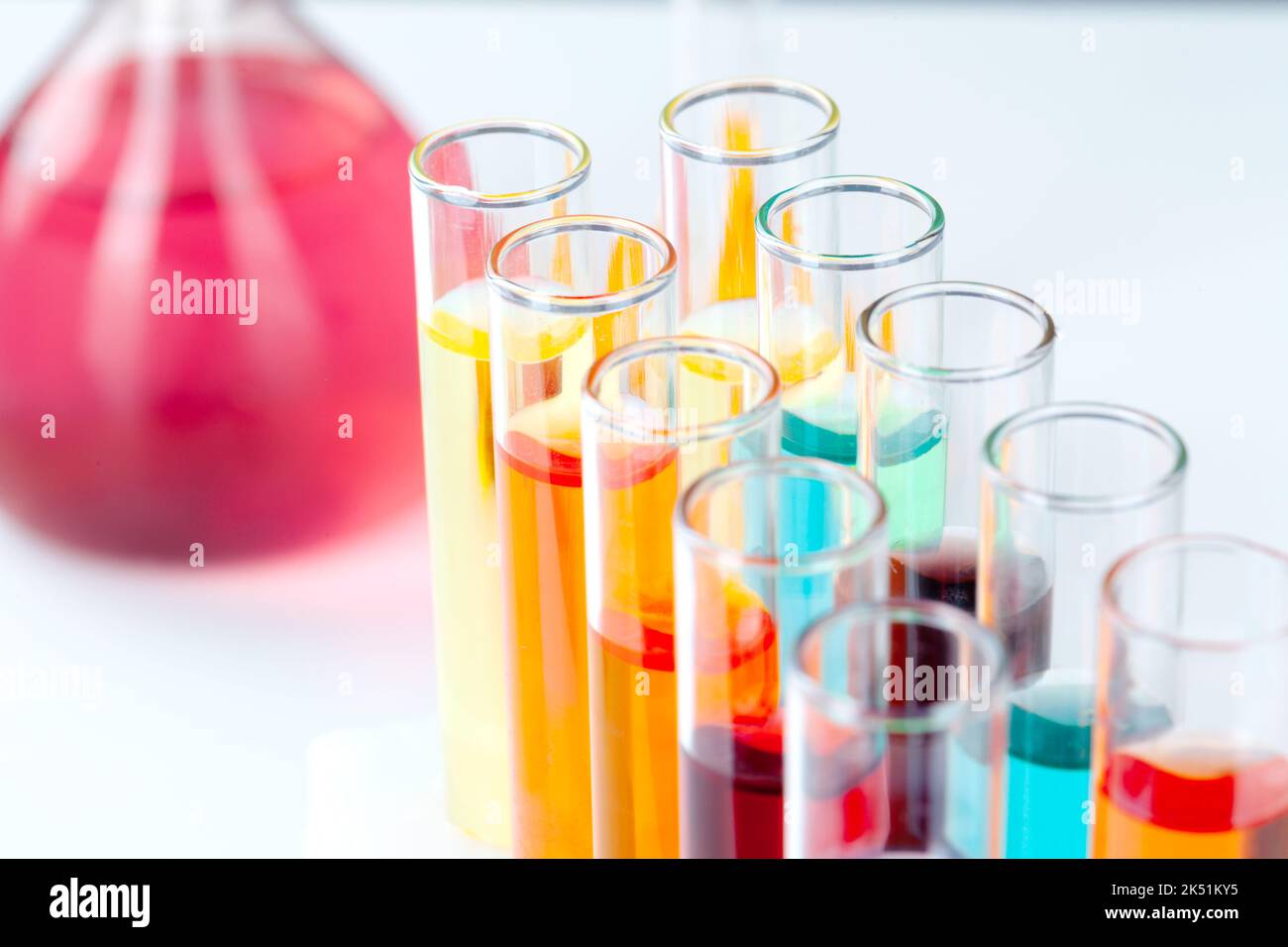 Colored liquids inside lab glassware on white table in laboratory Stock ...