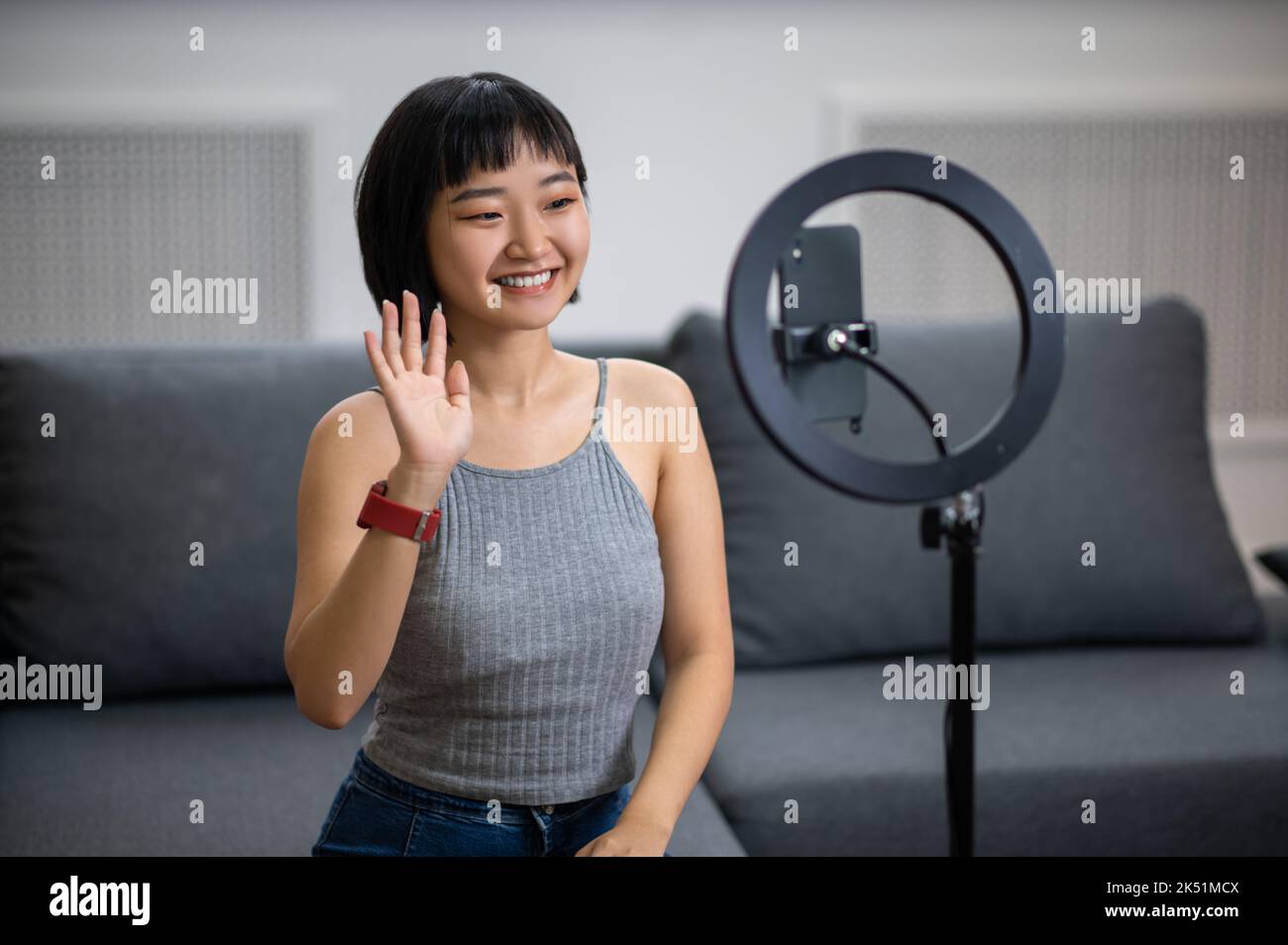 Cheerful female vlogger greeting her vlog audience Stock Photo - Alamy