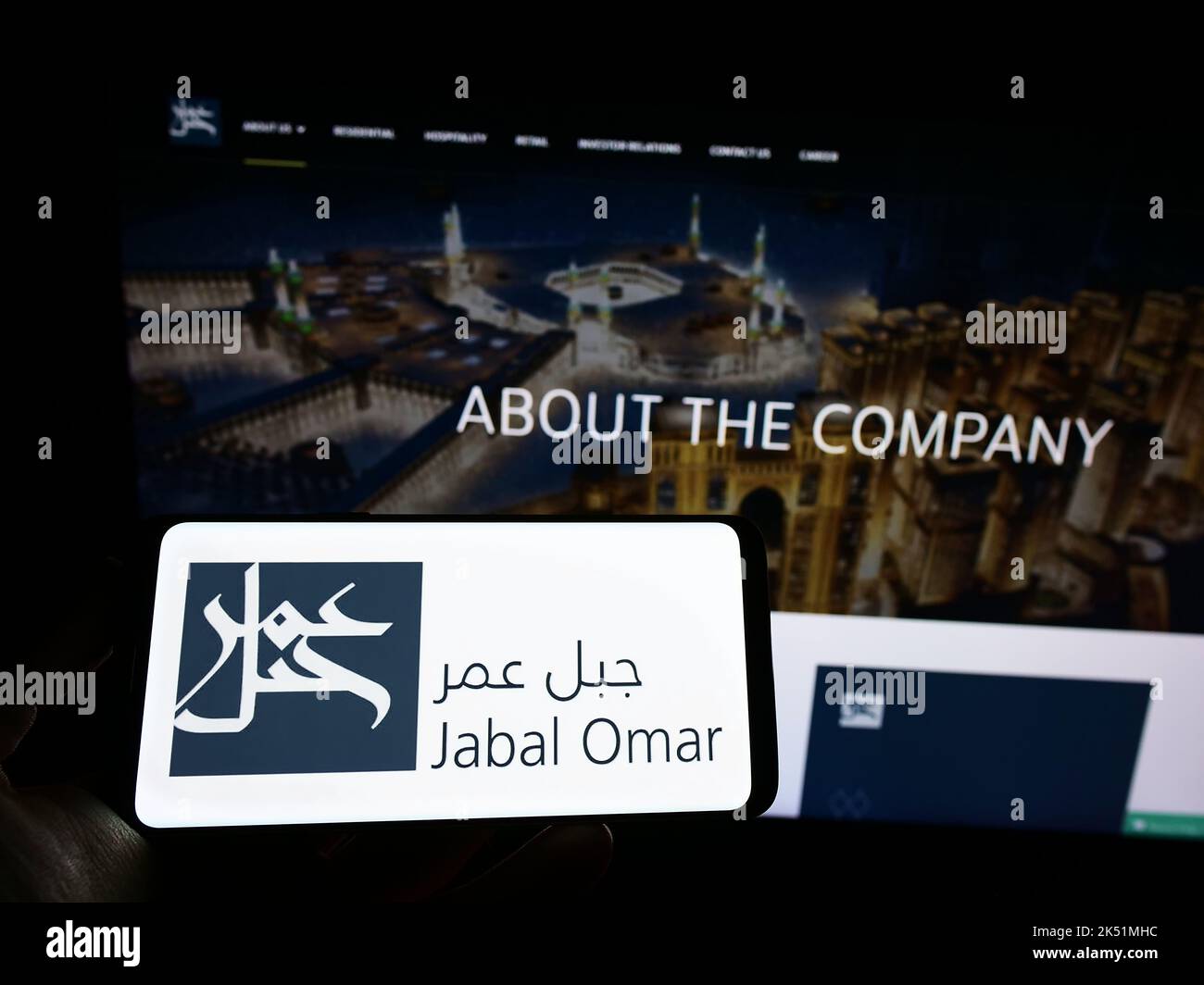 Person holding mobile phone with logo of Jabal Omar Development Company ...