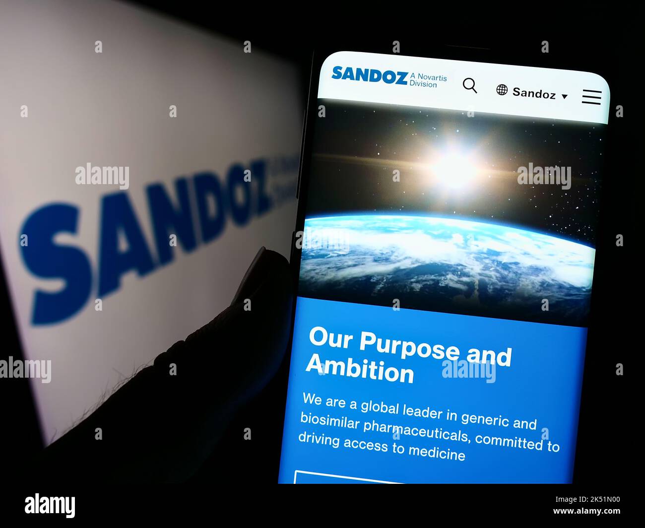 Person holding smartphone with website of pharmaceutical company Sandoz ...