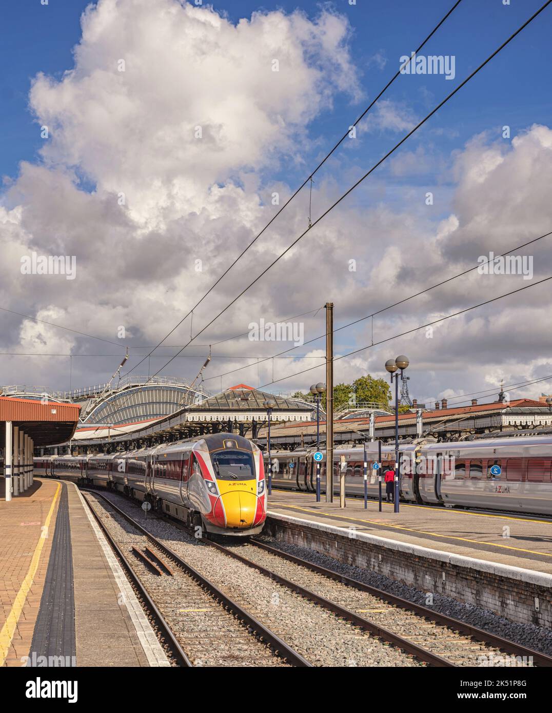 A train stops at a railway station platform. A locomotive is in the ...