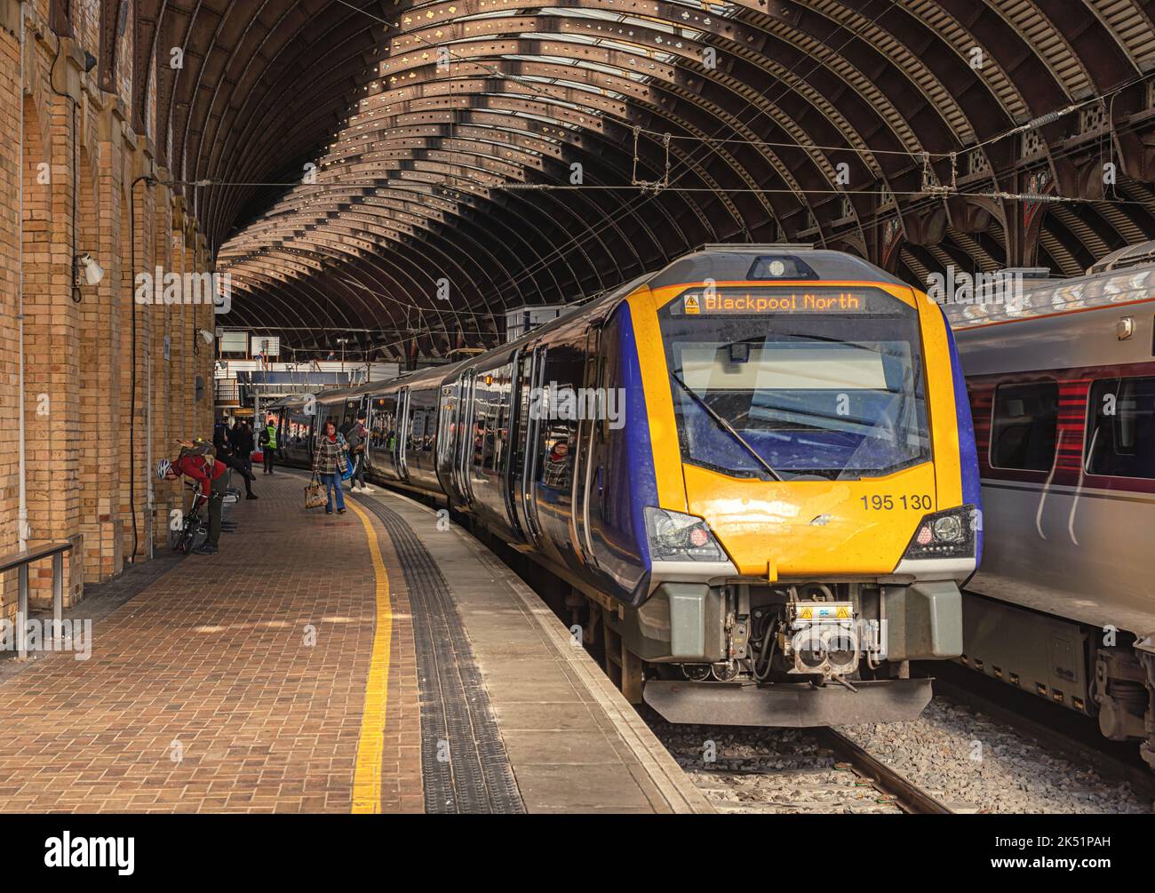 Railway carriages are resting alongside a station platform. There are ...