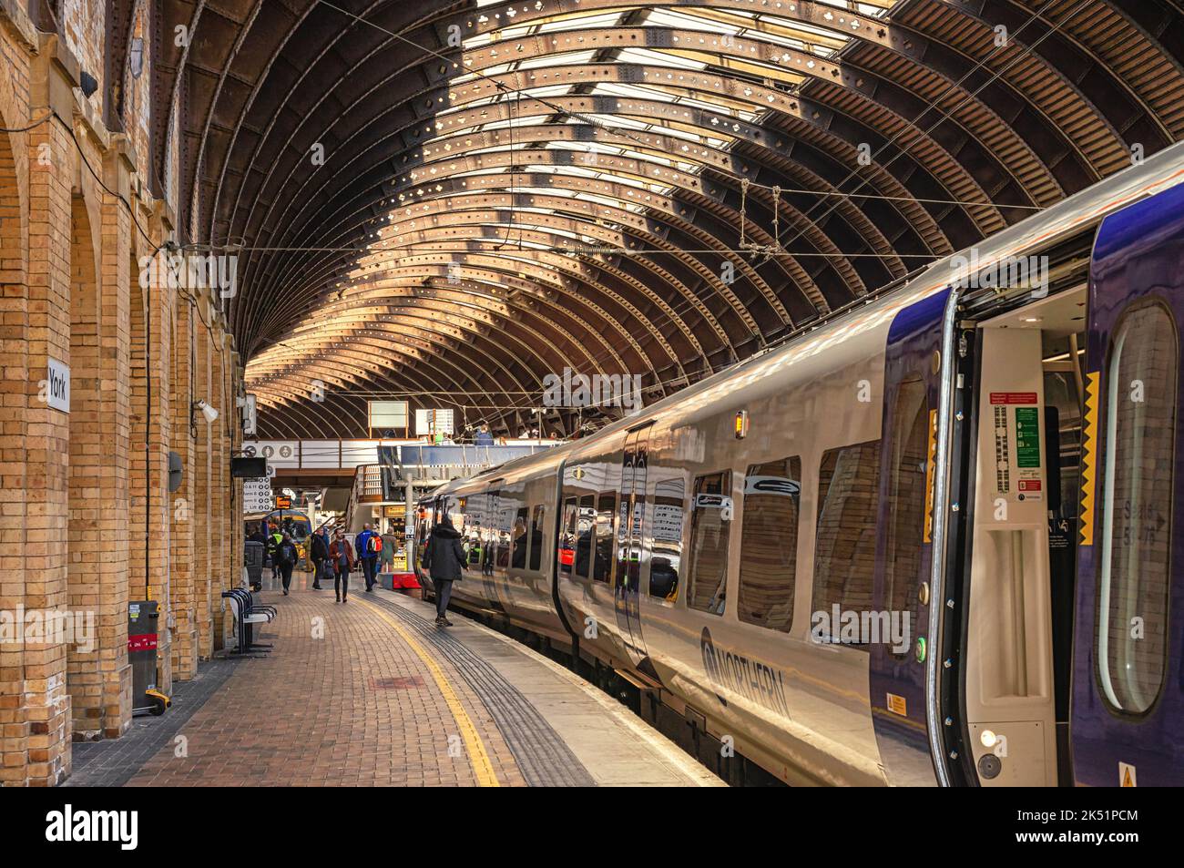 Railway carriages are resting alongside a station platform. There are ...