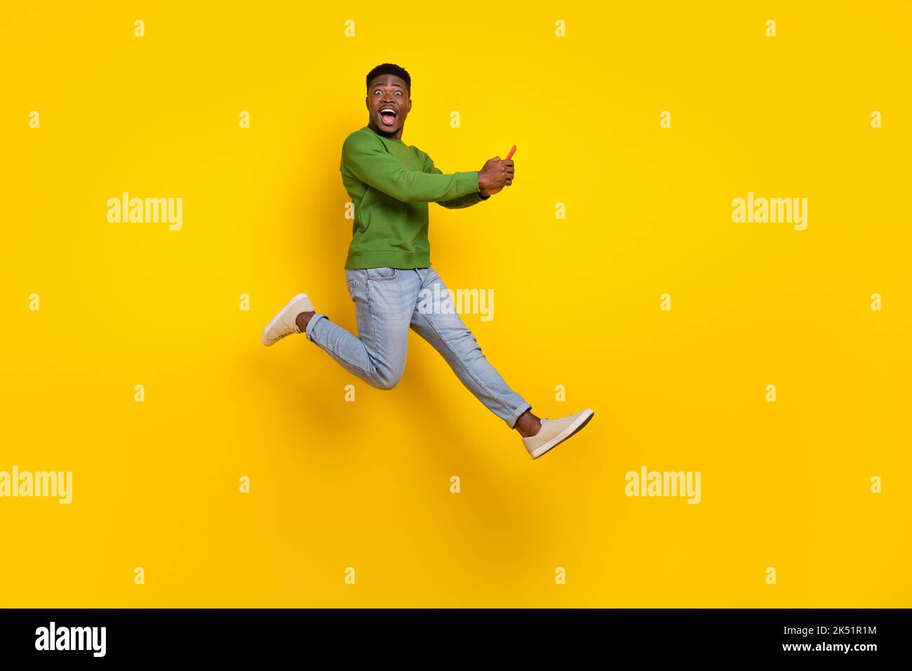 Full length body size view of handsome trendy guy using device jumping ...