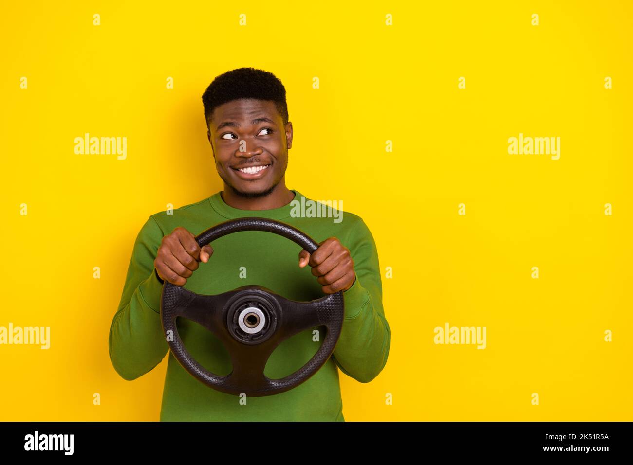 Portrait of attractive cheerful funny guy holding steering wheel ...