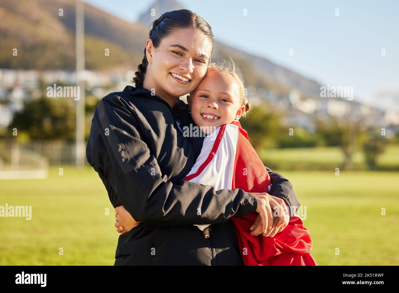Football coach, child and hug during sports training on outdoor field ...