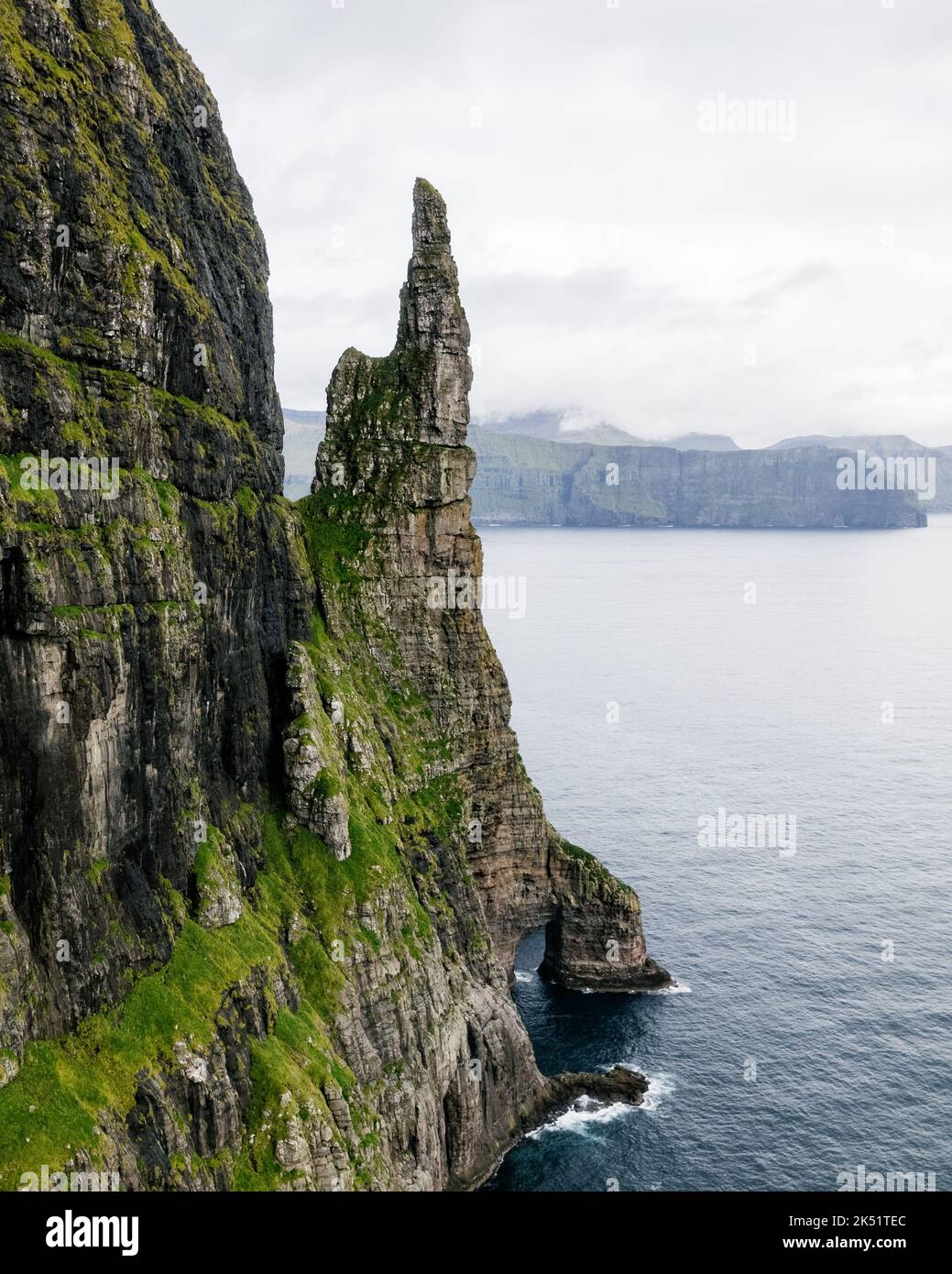 A rocky cliff forming a witches finger on the island of Vagar in the ...