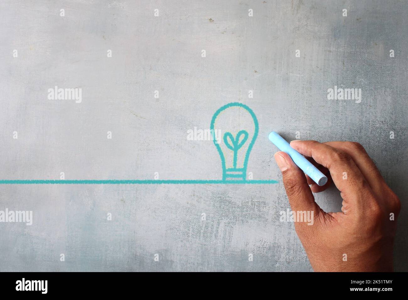 Top view image of hand drawing light bulb on chalkboard with copy space ...