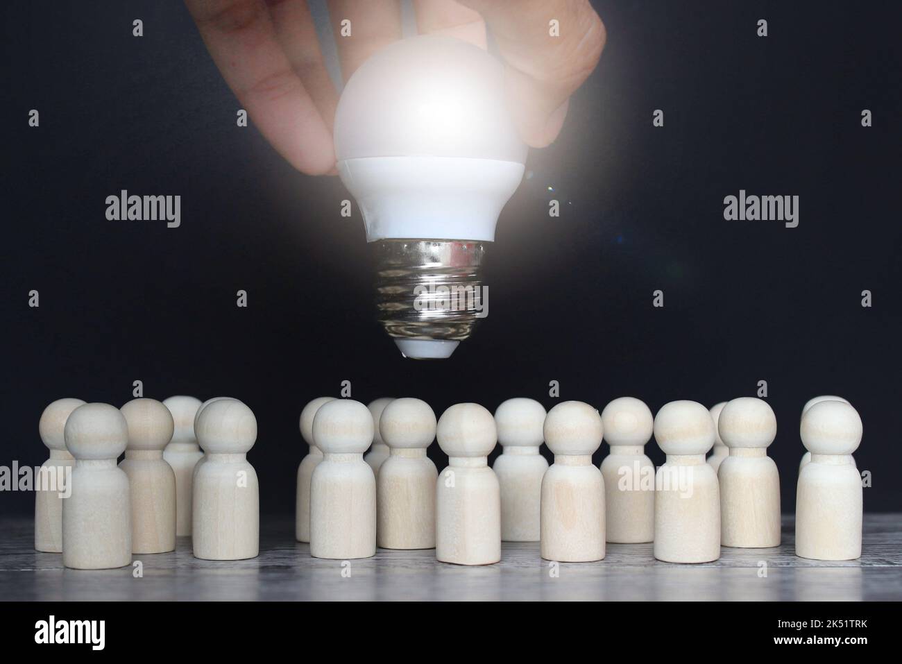 Wooden dolls and lightbulb. Brainstorming, joint project, innovation ...