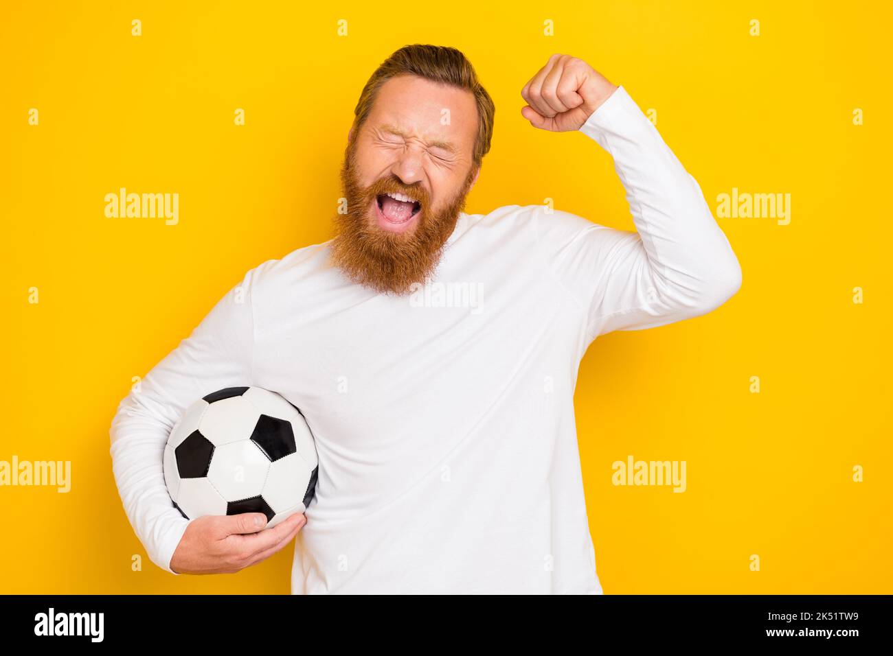 Portrait of delighted overjoyed man hold football raise fist shout yes ...
