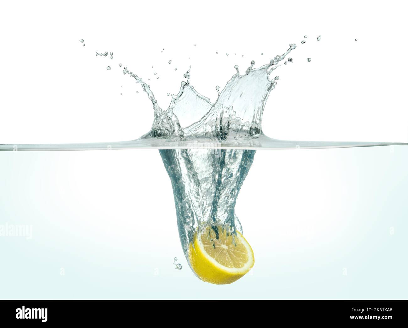 Half lemon splashing in clear water. Side view on white background ...