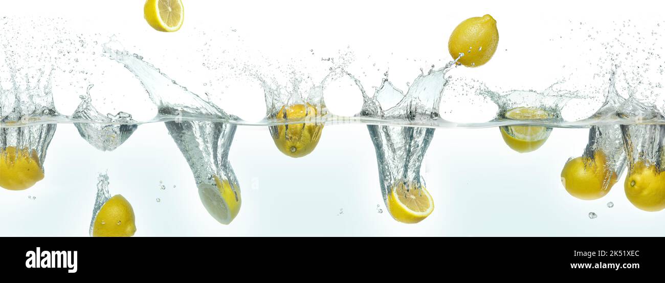 Many lemons splashing in water. Side panoramic view on white background ...