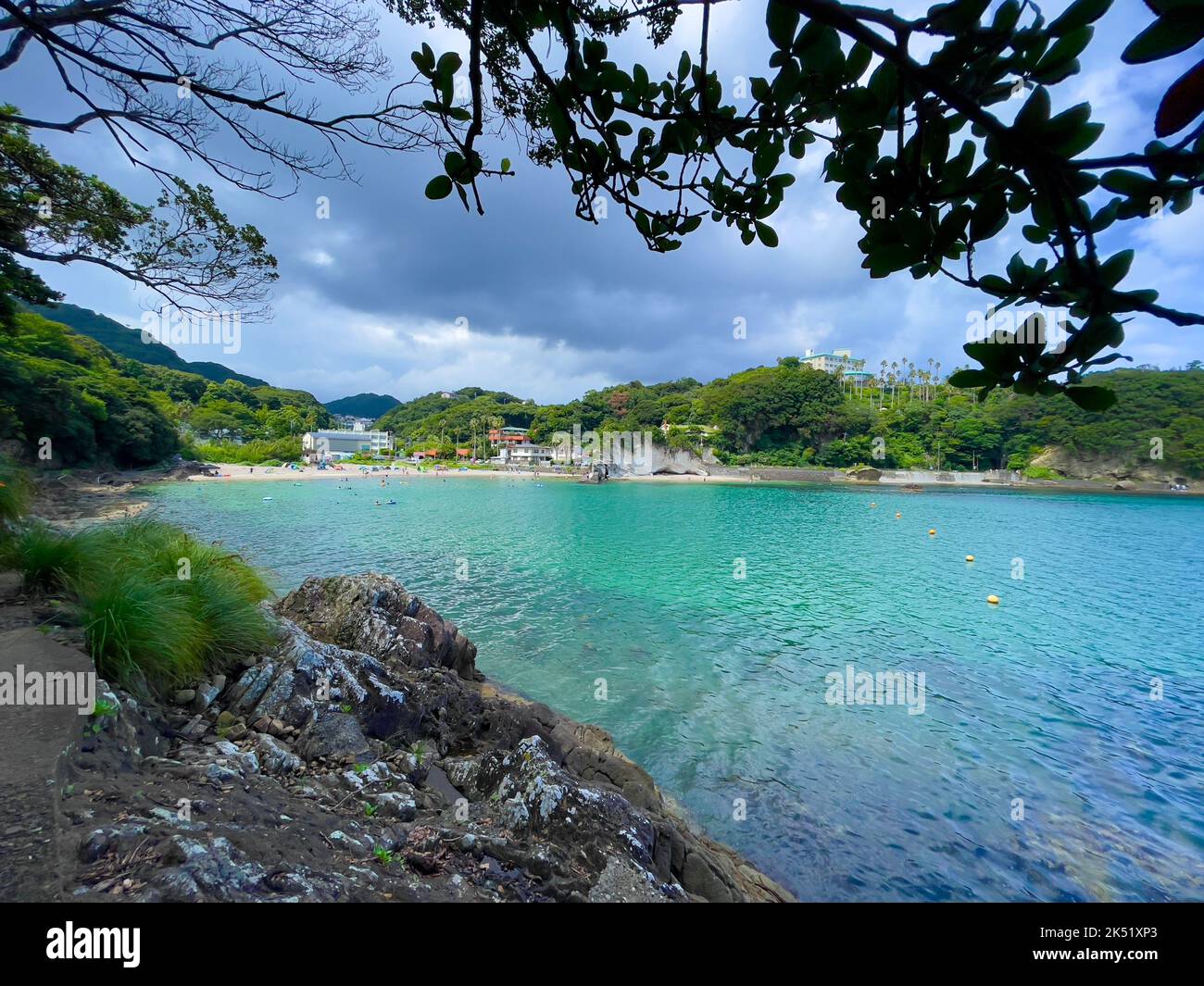 A blue coastline and people on the beach in the background of the Izu ...