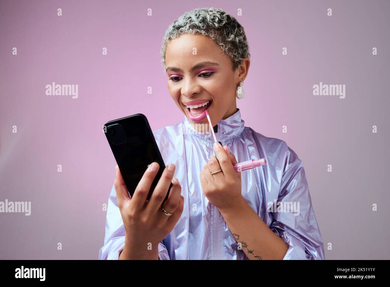 Fashion, phone and woman using lipstick in studio for beauty, makeup ...