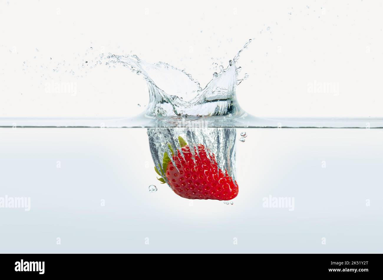 Strawberry splashing in water. Side view on white background Stock ...