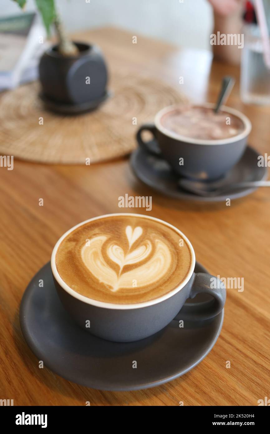 Coffee mugs placed on a table in a coffee shop, Latte art in a white ...
