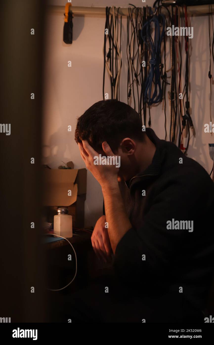 Defocus tired young man, engineer soldering black laptop. Electronic ...