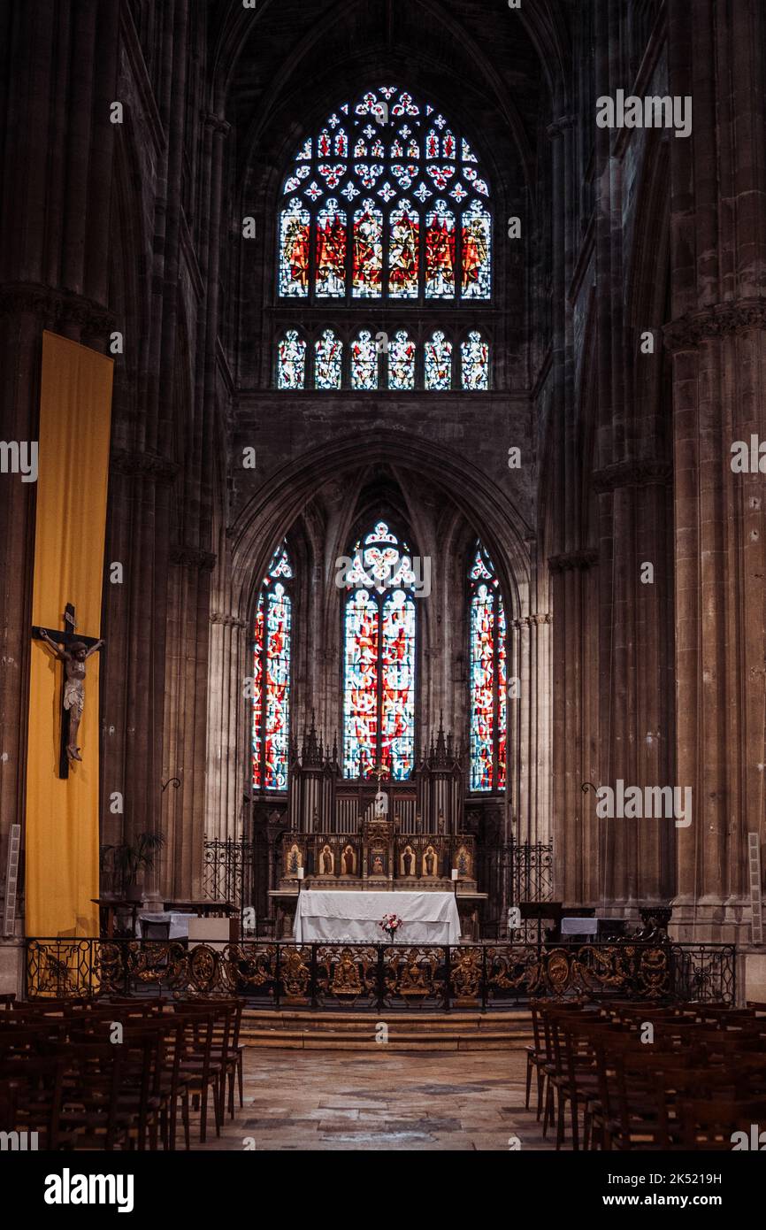 A vertical shot of the altar of a church with stained glass windows ...