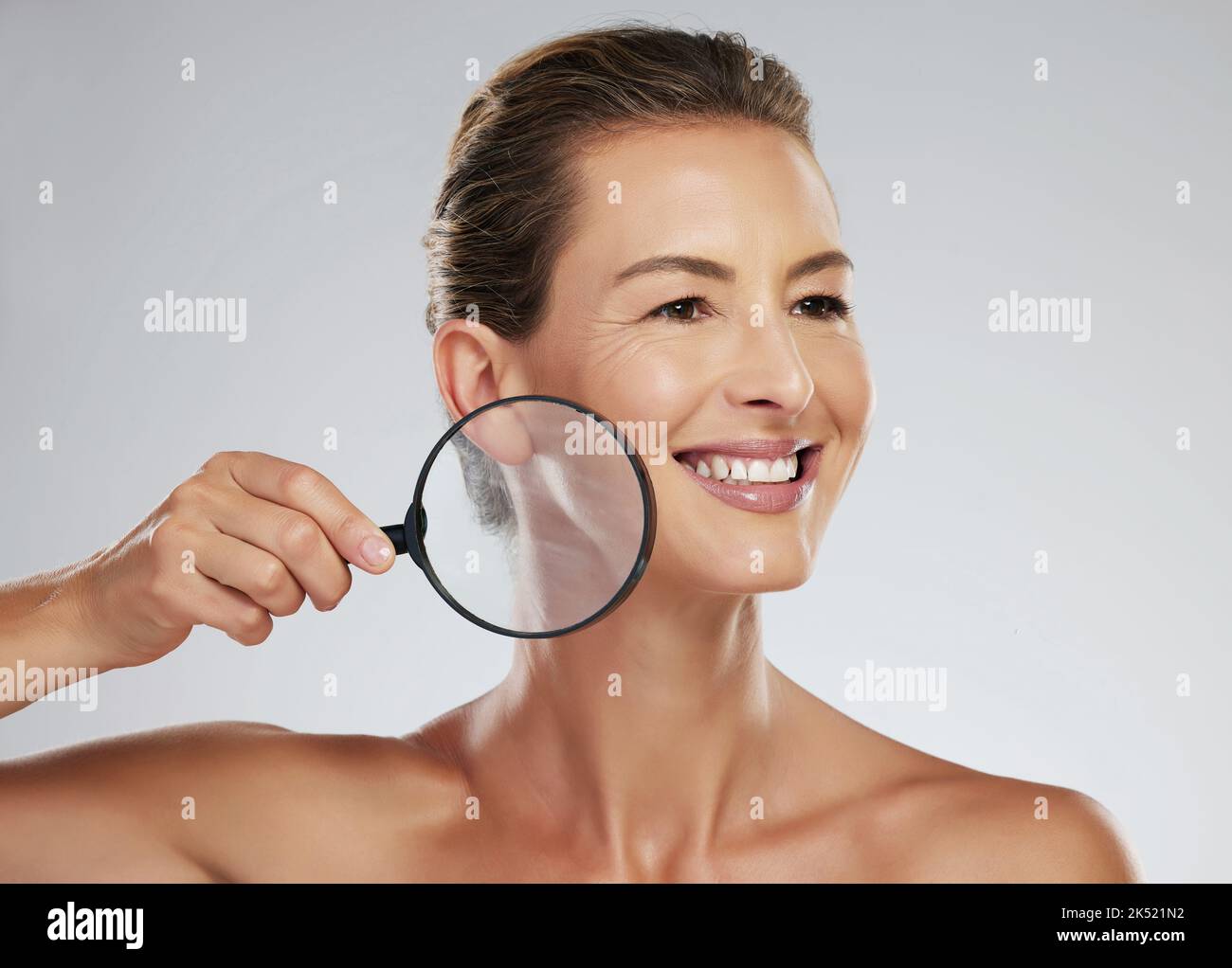 Mature woman, skincare and smile magnifying glass to zoom on face for ...